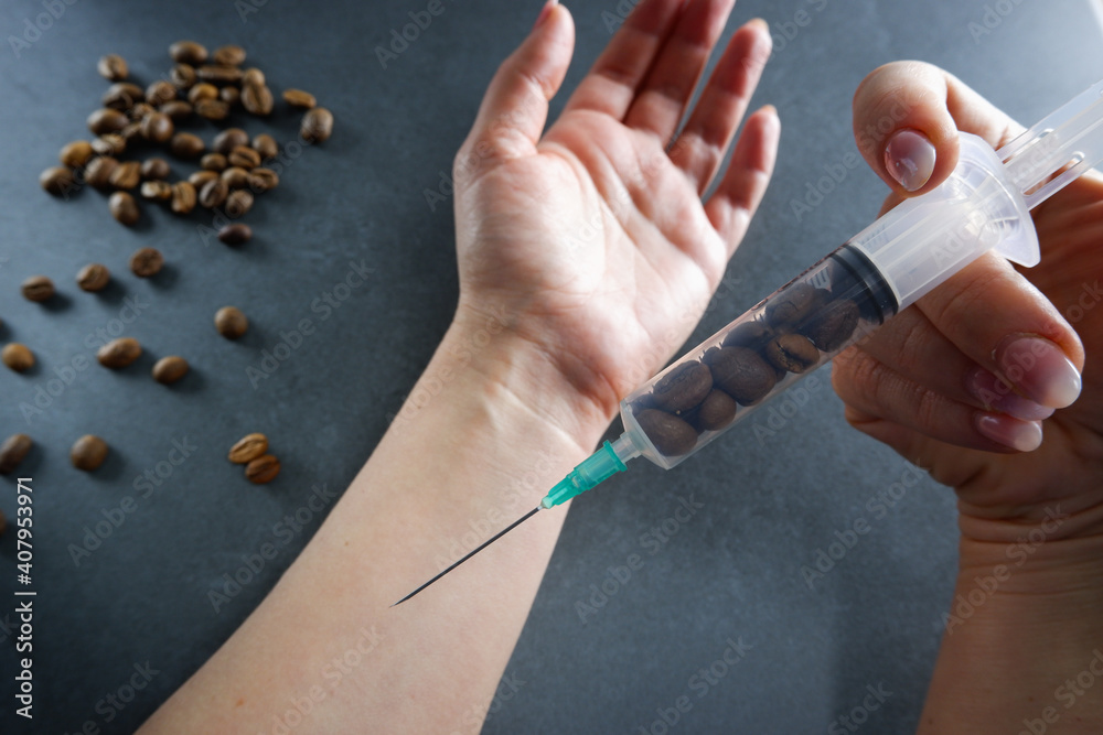 Grains of coffee and an injection syringe in female hands. Caffeine ...