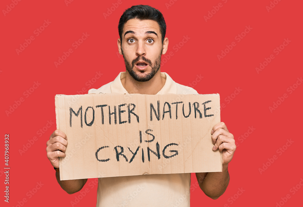 Young hispanic man holding mother nature is crying protest cardboard ...