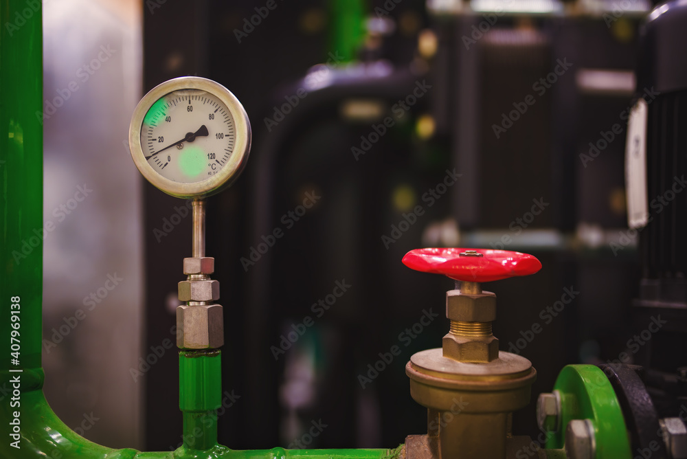 Red valve and analog temperature indicator (measuring in units of ...