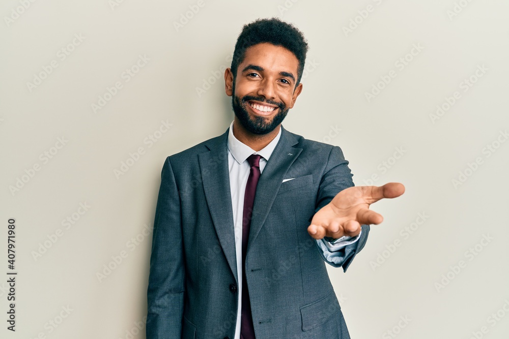 Handsome hispanic man with beard wearing business suit and tie smiling ...