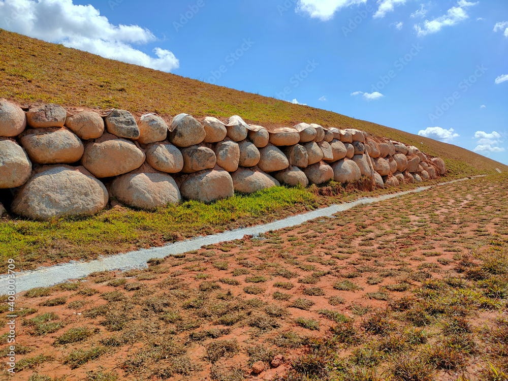 Natural boulders are used as retaining walls of ground banks that have ...