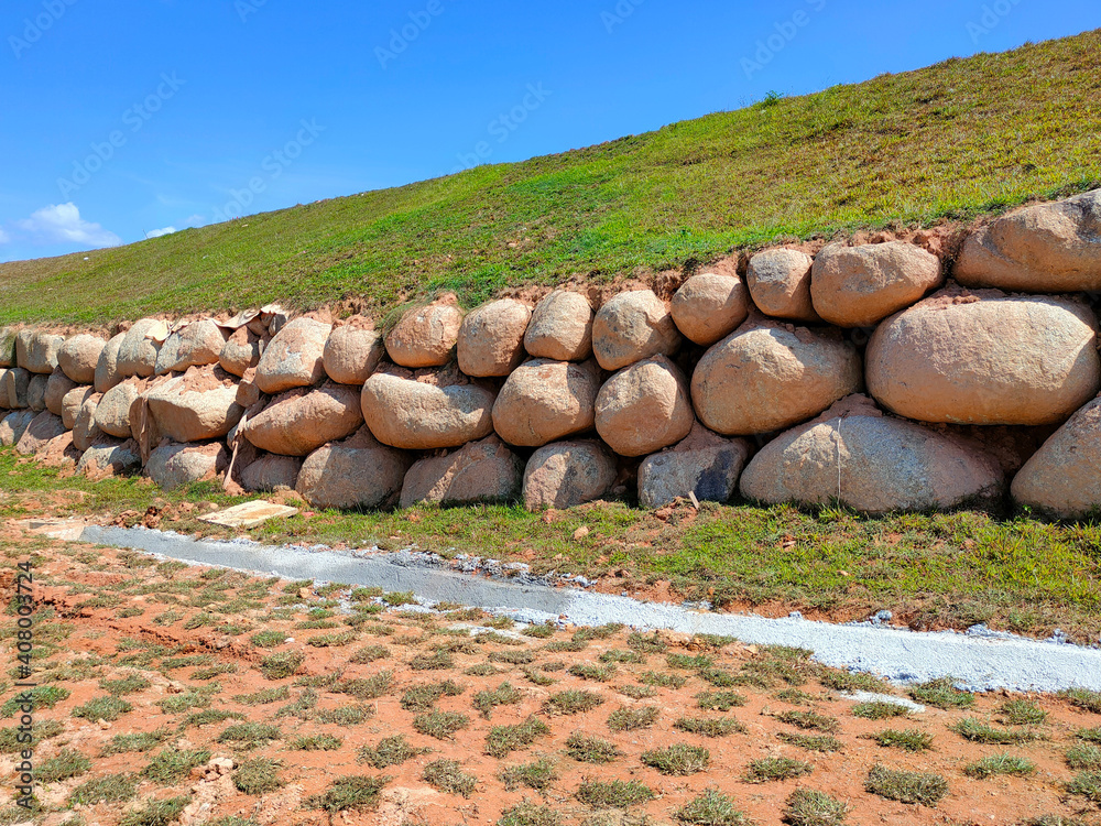Natural boulders are used as retaining walls of ground banks that have ...