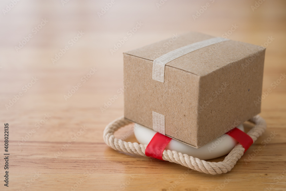 Parcel carton box on lifebuoy with wooden table background. Parcel or ...