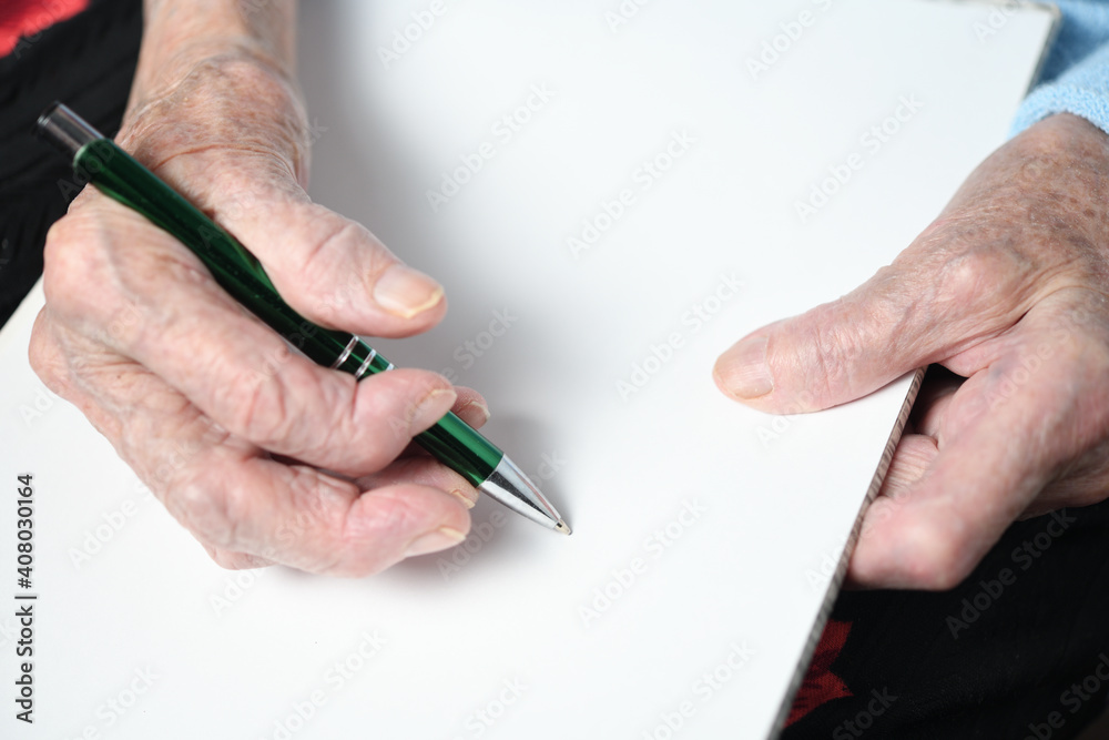 Hands of an old woman with a sheet for writing text.The hands of an old ...