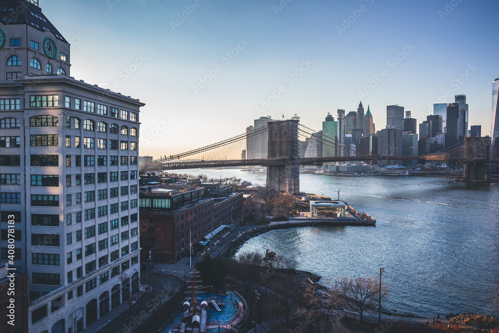 New York City skyline with skyscrapers at sunset. Brooklyn bridge as a ...