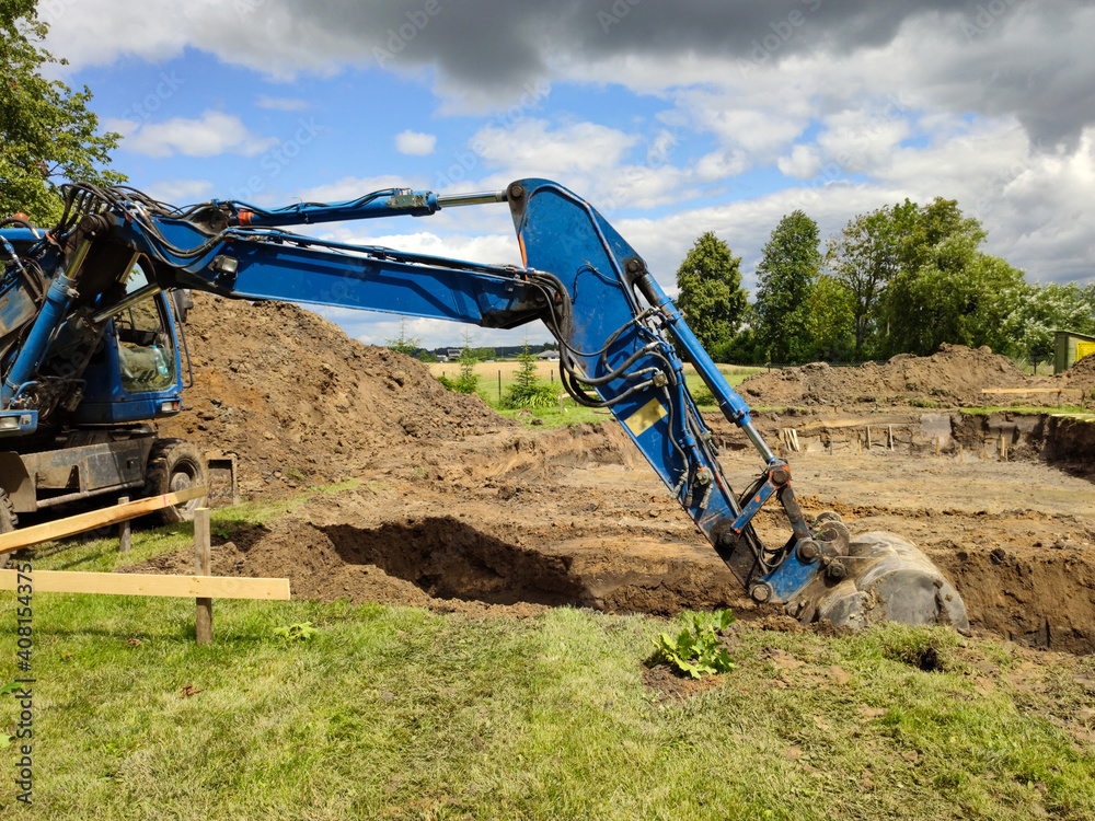 A work excavator digging a trench for the foundation of a building ...
