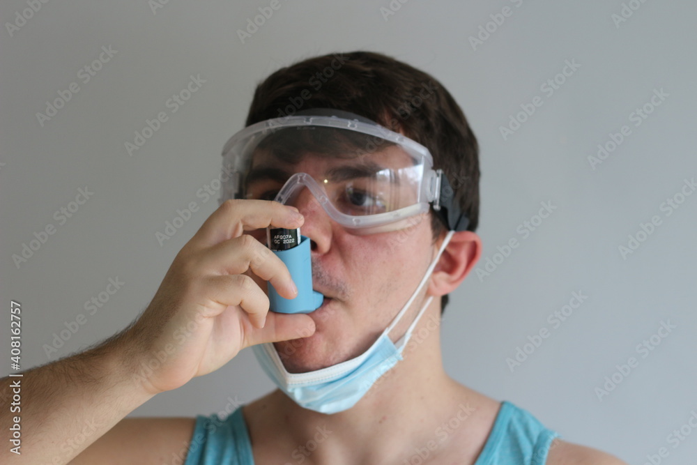 man in full ppe shows how to use a rescue inhaler Stock Photo | Adobe Stock