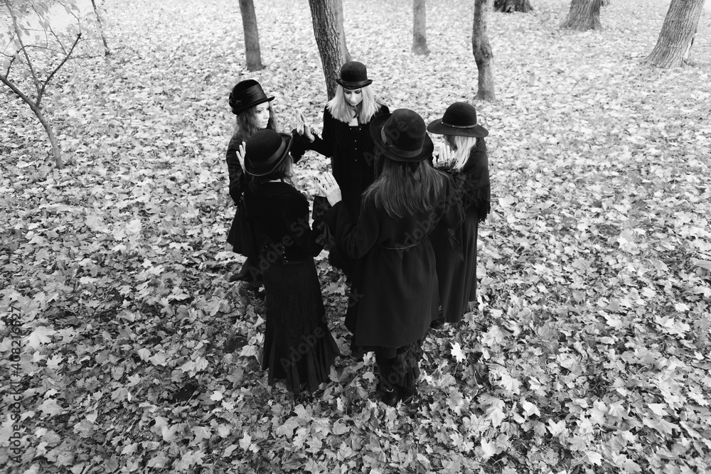 Coven of witches, a group of friends as witches on Halloween perform a ...