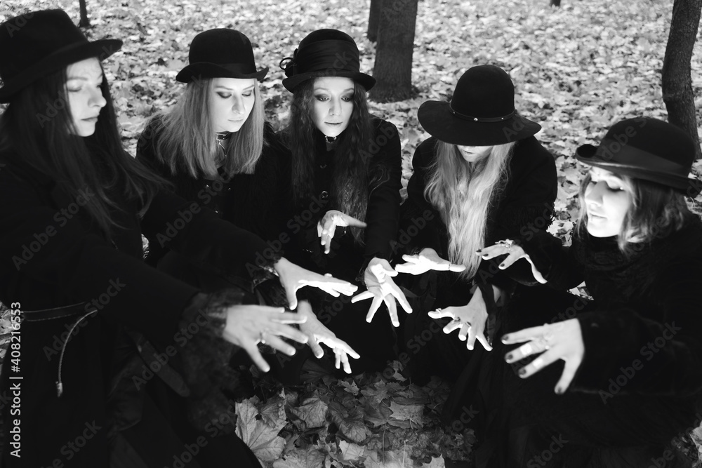 Coven of witches, a group of friends as witches on Halloween perform a ...