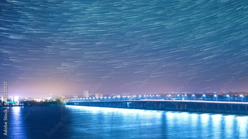 Beautiful long bridge in bright cold lights across a gleaming river, 4K ...