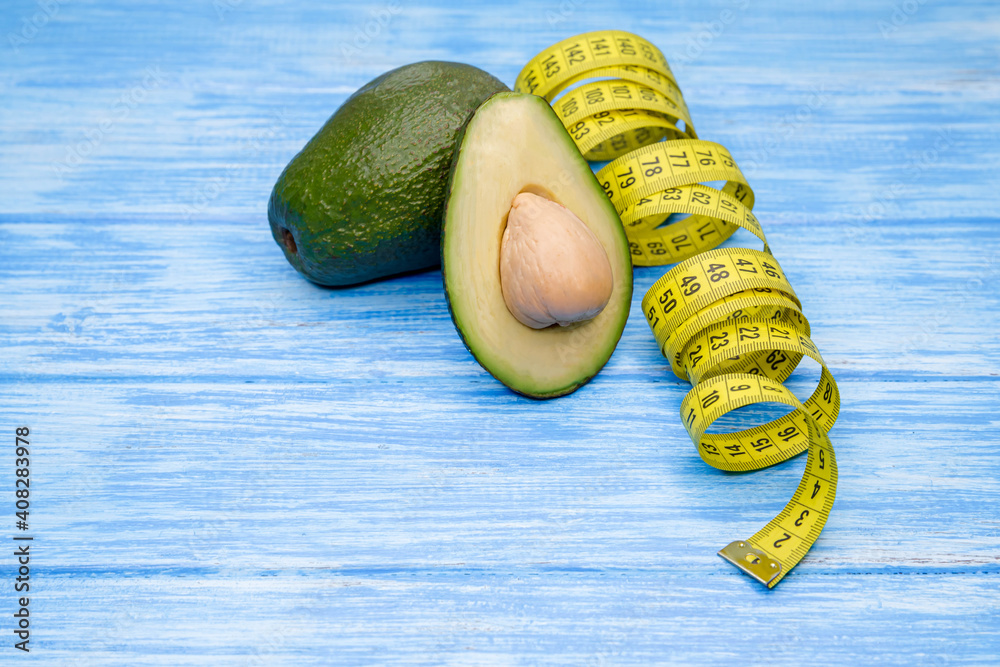 Ripe avocado cut in half on a wooden board. Whole and halved avocado ...