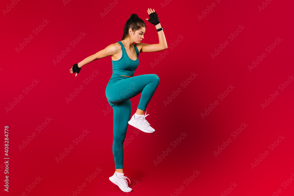 Fitness girl in sportswear does exercises to train leg muscles. Red ...