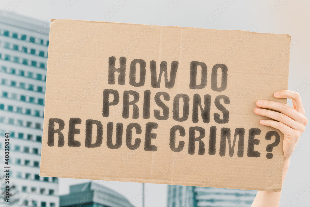 The question " How do prisons reduce crime? " on a banner in men's hand ...