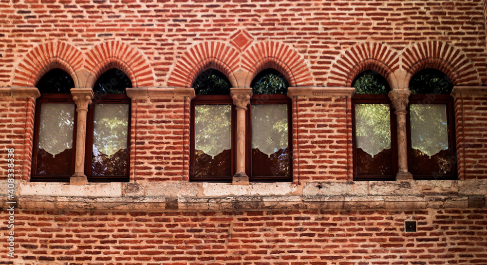 Fenêtres médiévales en arcades d un bâtiment en briques rouges. Stock ...
