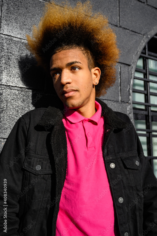 Hombre joven latino, moreno con pelo rizado a lo afro sentado en un ...