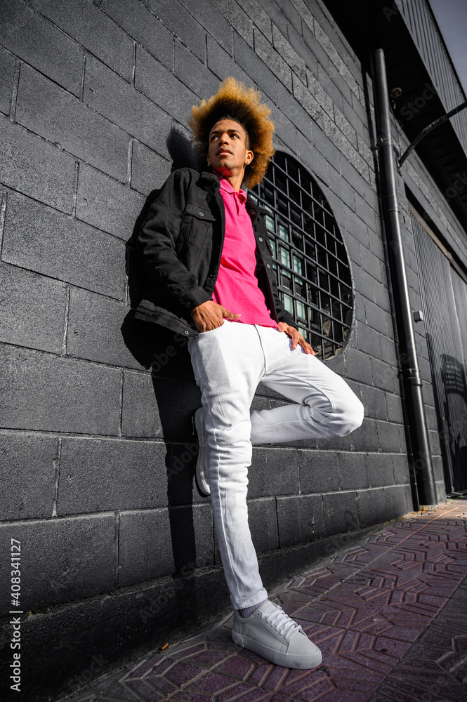 Hombre joven latino, moreno con pelo rizado a lo afro sentado en un ...