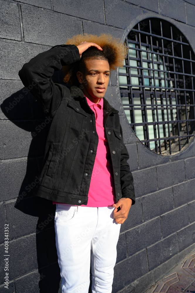 Hombre joven latino, moreno con pelo rizado a lo afro sentado en un ...