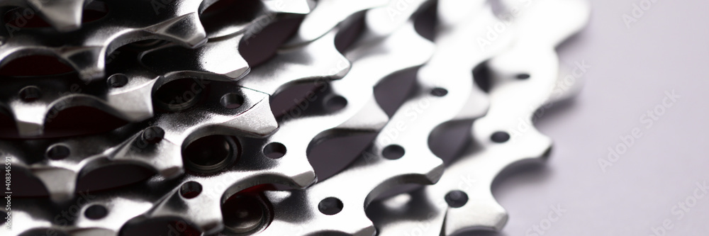 Cropped photo of new parts of metal gear on grey background. Shiny gear ...