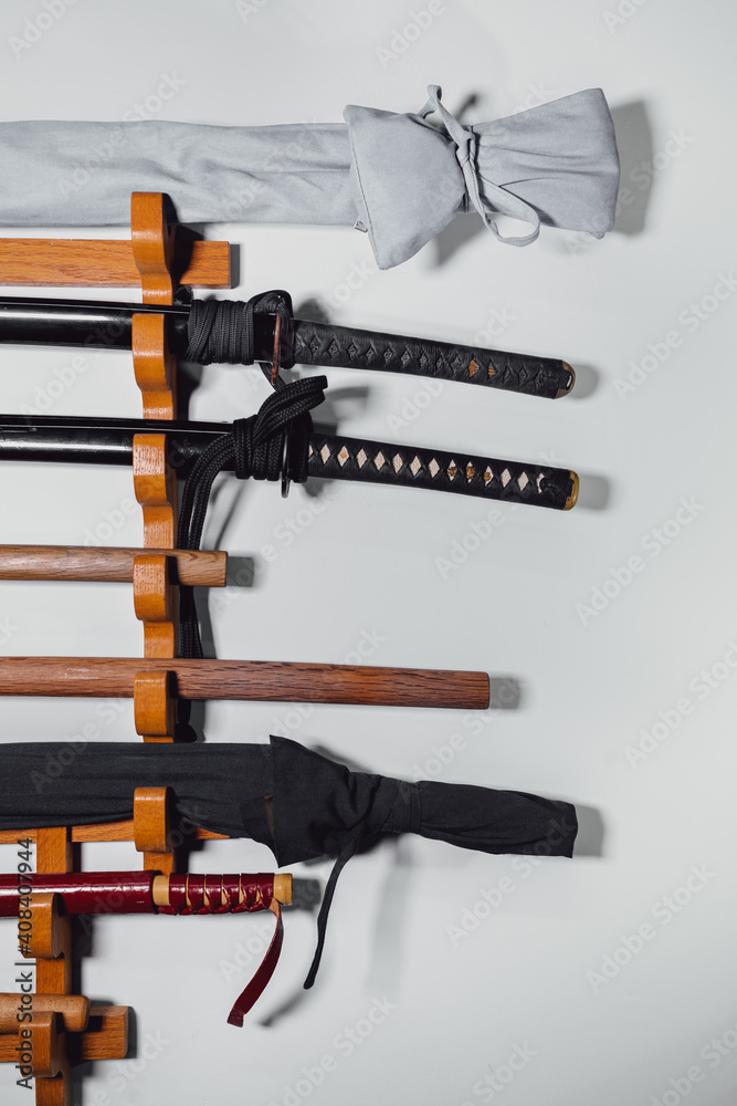 Special stand on the white wall for training swords made of oak wood ...