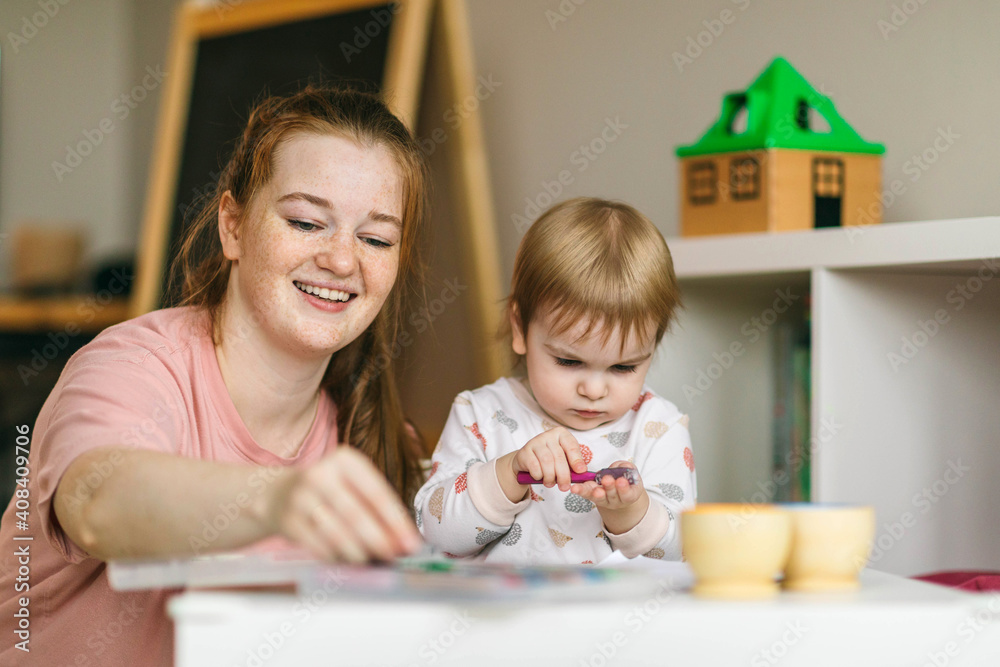 Early childhood learning. Mother and child play with wooden beads and ...