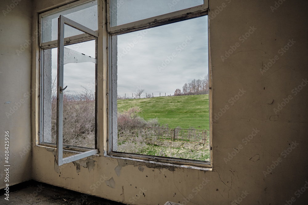 Old type window made of wood with scene of small hill covered by green ...