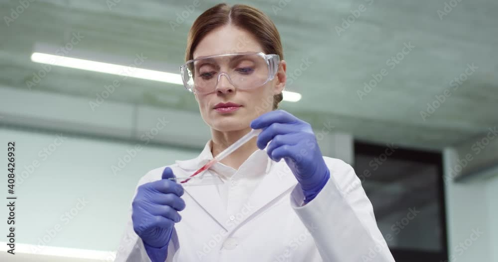 Close up of serious young Caucasian pretty female laboratory worker in ...