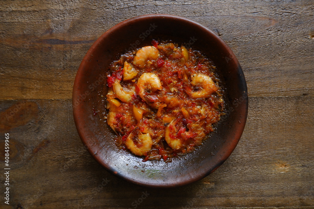 a plate of prawn cooked in sambal in an earhenware plate named gami ...