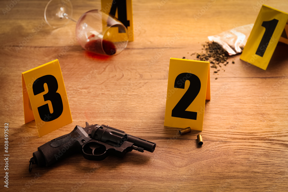 Crime scene markers, gun and shell casings on wooden table Stock Photo ...