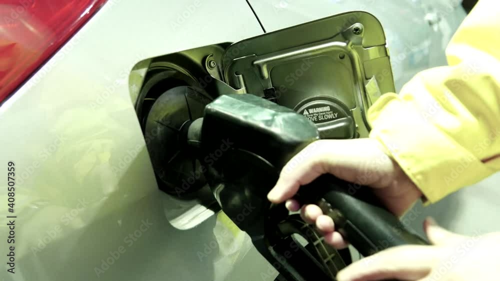Filling up car gas tank with fuel at the station. Closeup on hand and ...