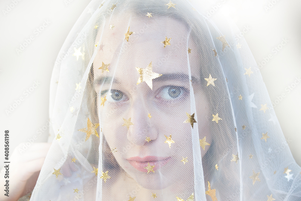 Beautiful young girl close-up in the image of the bride. A white veil ...