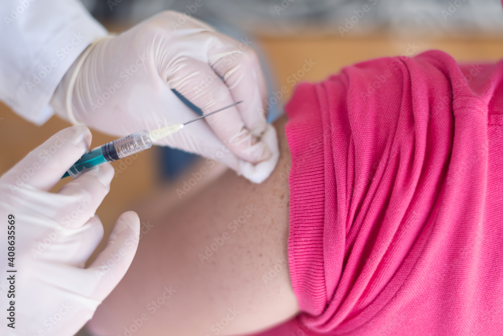 Close up of a Doctor making a vaccination in the shoulder of patient ...