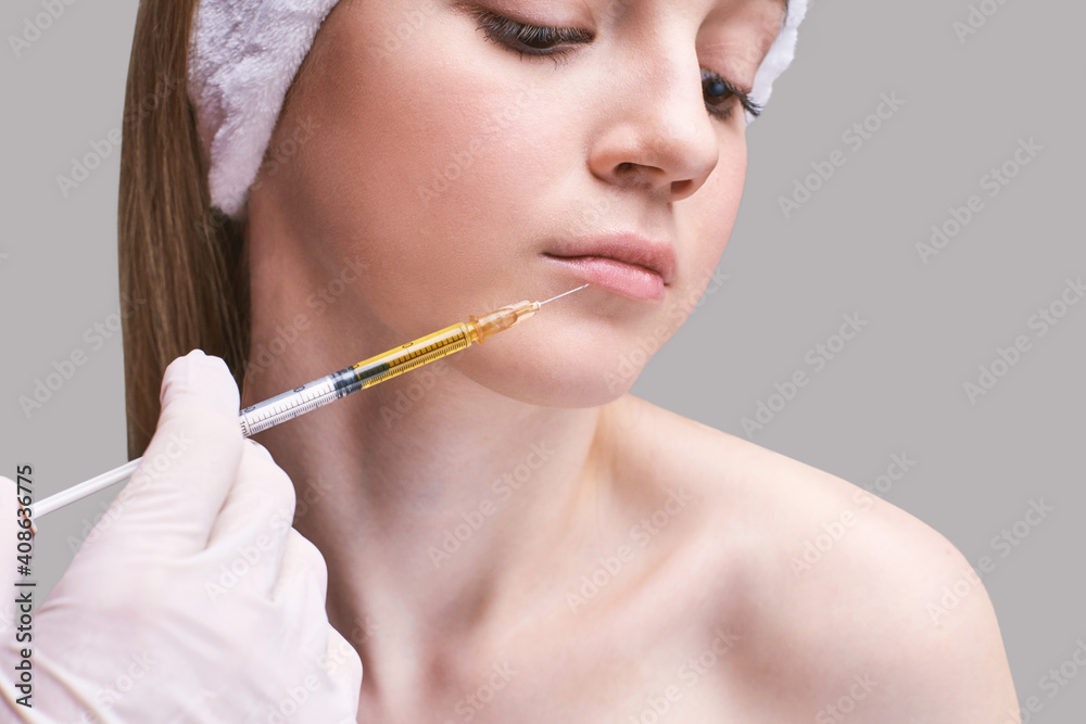 Lips injection at spa salon. Doctor hands. Pretty female patient ...