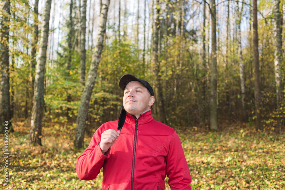 Young man takes off his mask outdoors. Portrait of a young man takes ...