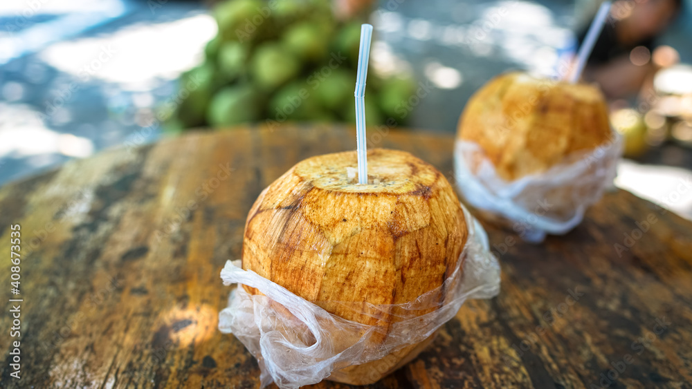 Sweet coconut on the table, refreshing coconut drink. Asian street fast ...