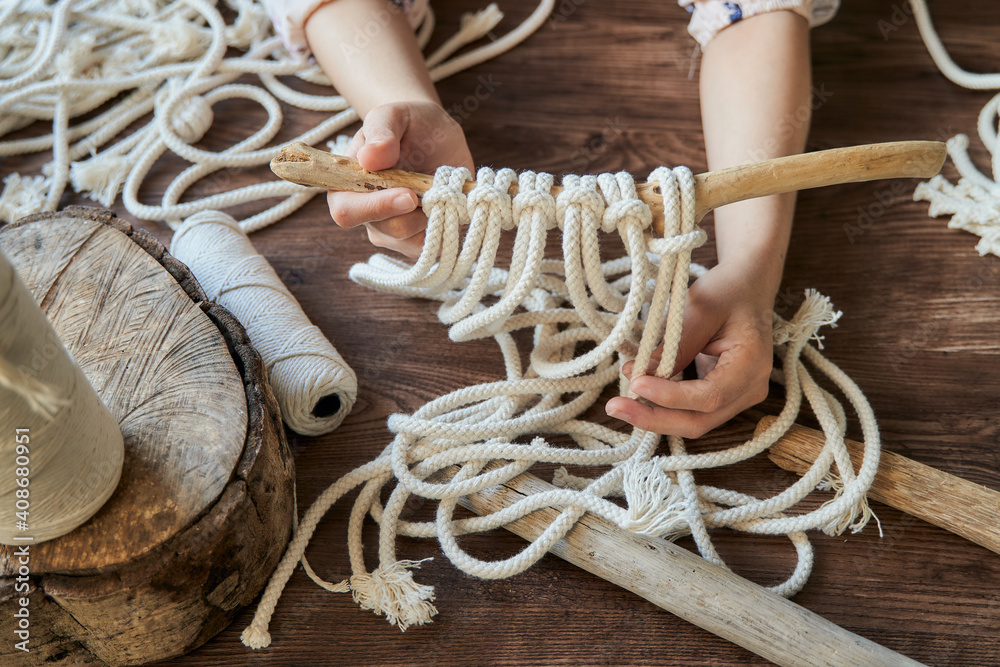 Female hands in a workspace showing how to make a macrame decoration ...