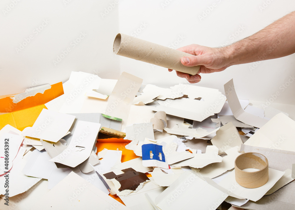 Man's hand tosses a sleeve of paper towels into a container for ...