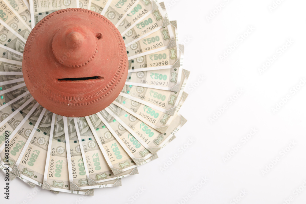 Clay piggy bank pot with five hundred rupees bank note in indian ...