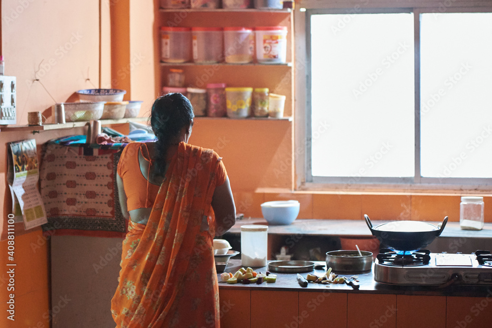 preparing ingredients and cooking a meal in the kitchen of an Indian ...