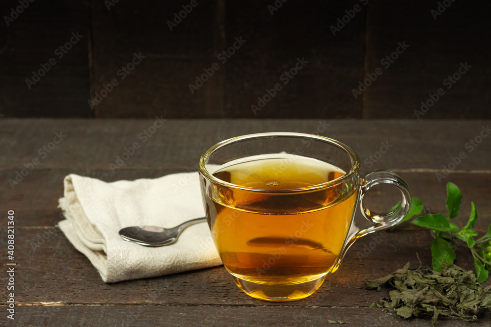 Tulsi or holy basil tea in transparent glass cup with fresh and dry ...