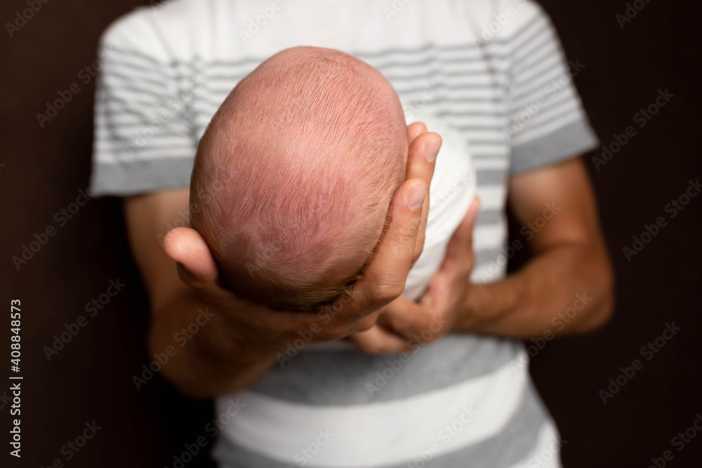the child's head in the hands of parents. the head of the newborn in ...