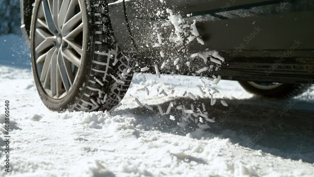 SLOW MOTION, LOW ANGLE, CLOSE UP, DOF: Car's wheels spin in place and ...