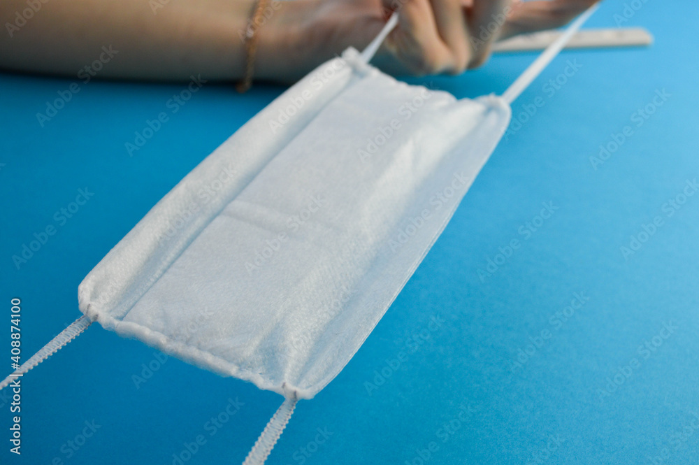 white mask on a blue background. sterile, disposable mask to protect the body from viruses ...