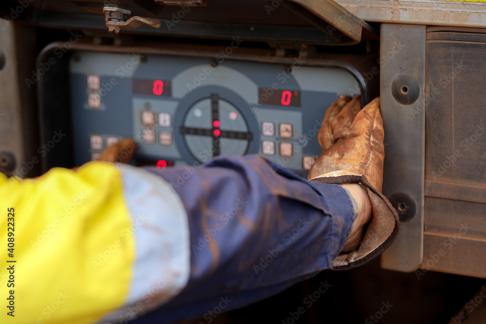 Male crane operator hand wearing safety glove controlling out trigger ...