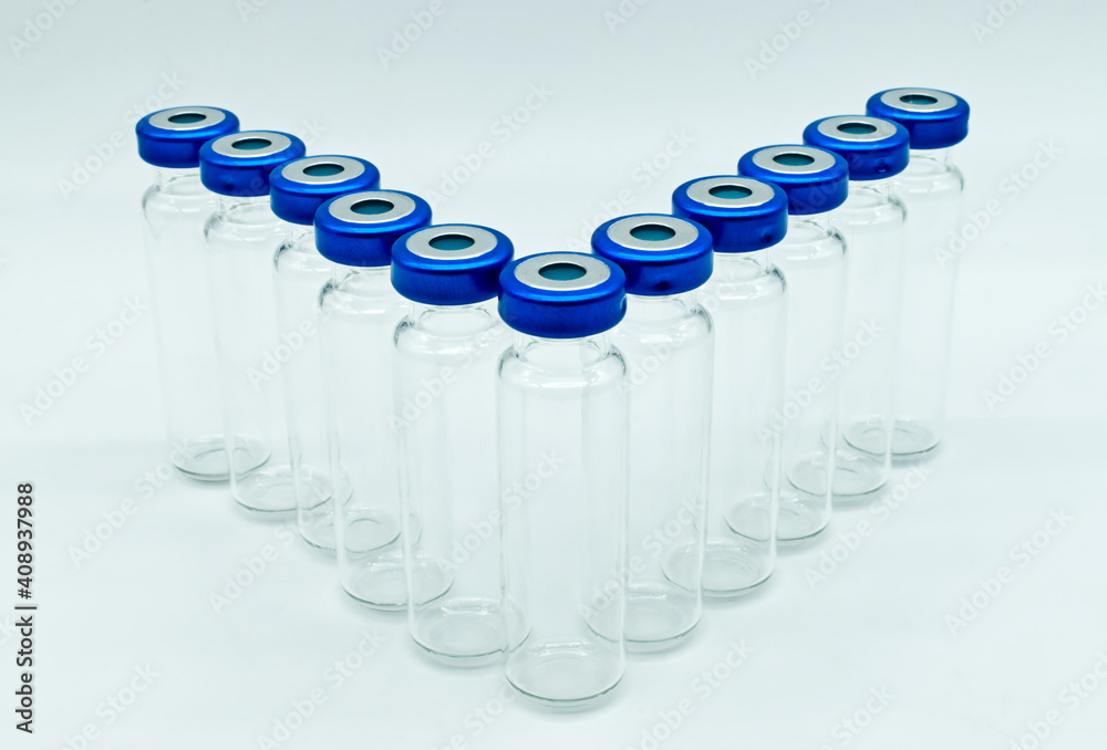Row of transparent glass medical vials for injection with blue sealed ...