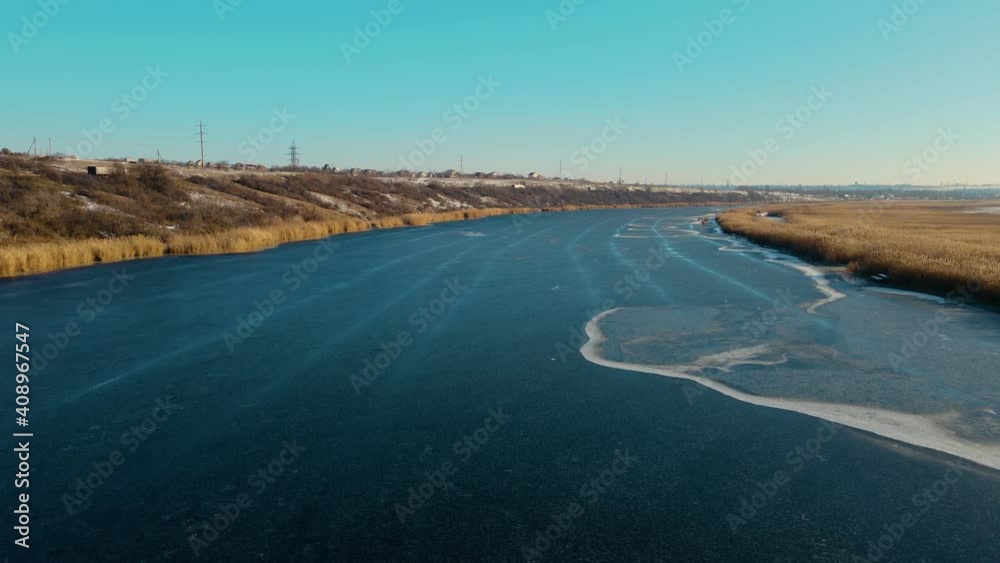 Frozen river in snowy winter near highway on hill with moving heavy ...