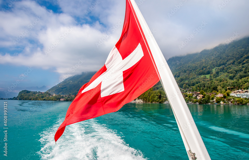 Swiss flag over landscape of lake Brienz. Interlaken, Switzerland ...