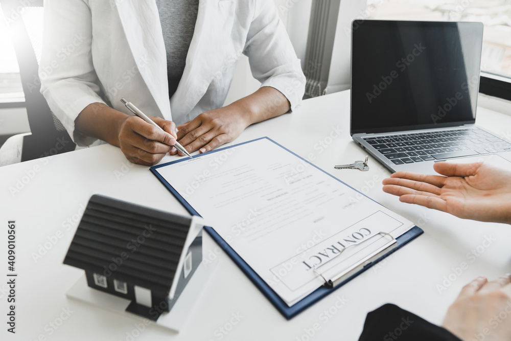 Customers interested in buying a home sign a signature to enter into a ...