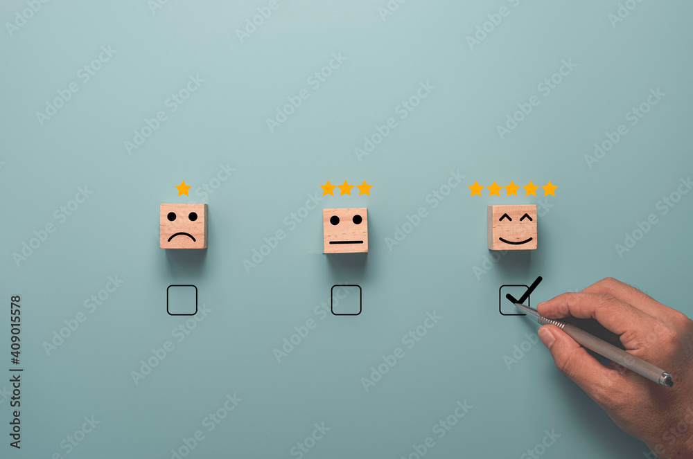 Hand writing check mark to select smile face with five stars on blue ...