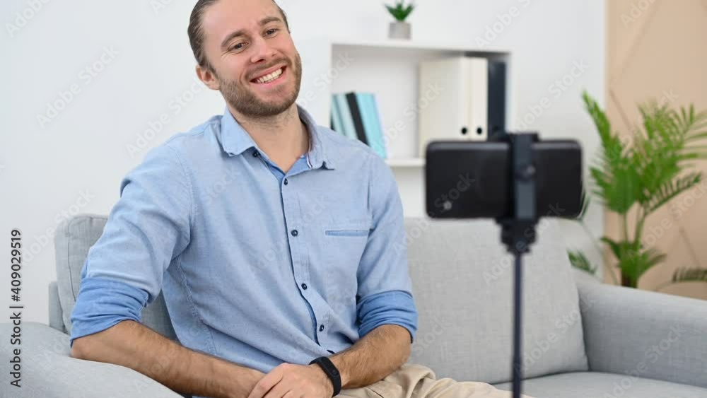 A handsome guy is recording himself on a smartphone, making blog ...