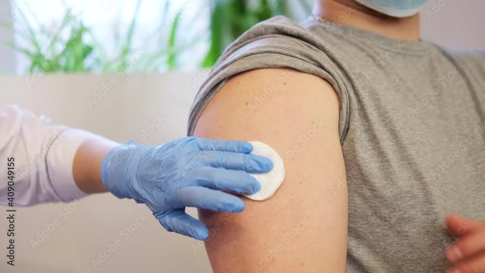 Close up of a Doctor making a vaccination in the shoulder of patient ...
